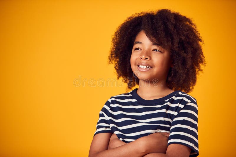 Studio Portrait of Smiling Young Boy Shot Against Yellow Background ...