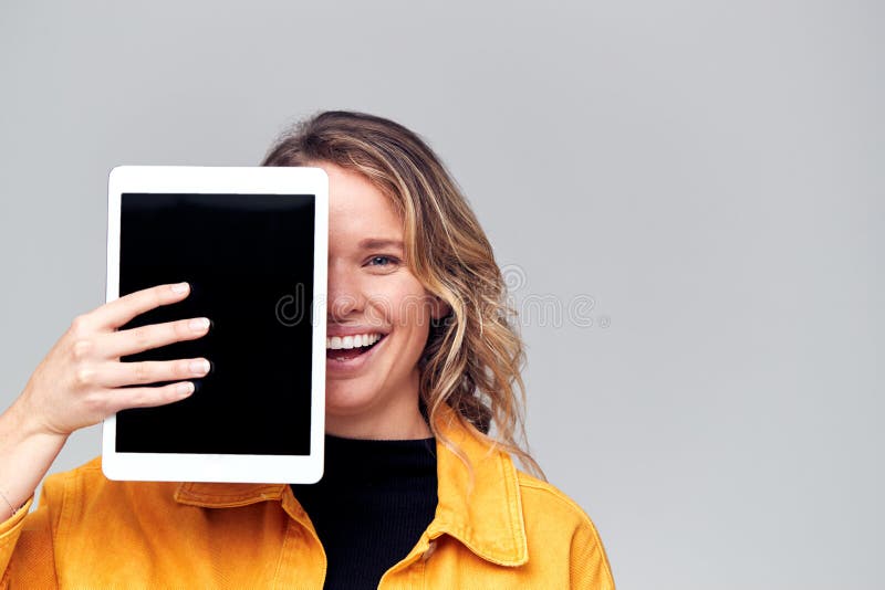 Studio Portrait of Smiling Young Woman Covering Face with Digital ...