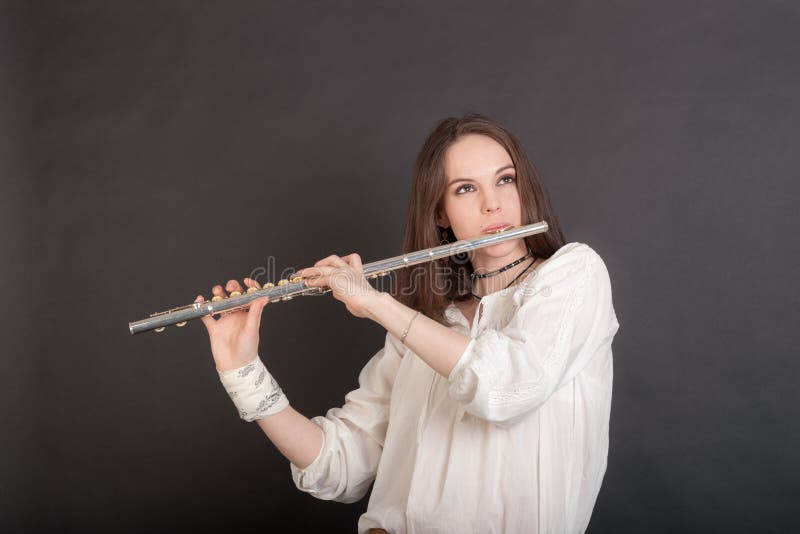 Woman playing the flute stock image. Image of young - 242522957