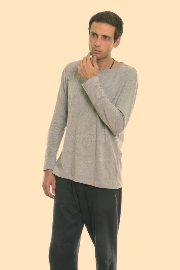 Studio Shot of Young Handsome Man Standing and Thinking while Looking ...