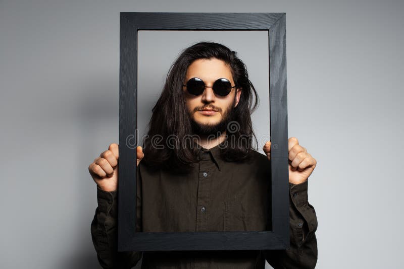 Studio Portrait of Young Man Holding Empty Picture Frame of . Stock ...
