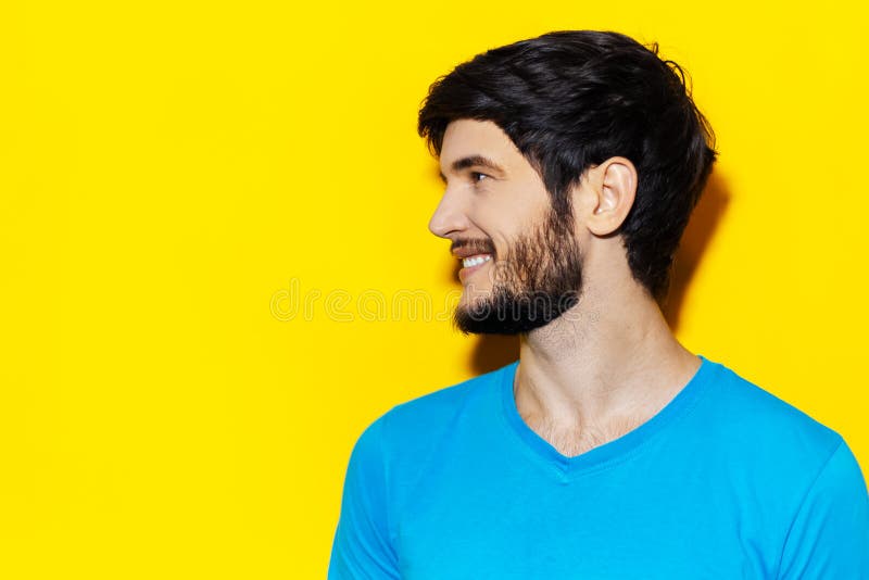 Studio Profile Portrait of Young Smiling Guy in Cyan Shirt Looking on ...