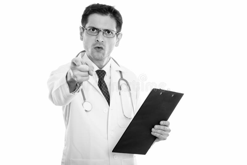 Studio Shot of Angry Young Man Doctor Holding Clipboard while Pointing ...