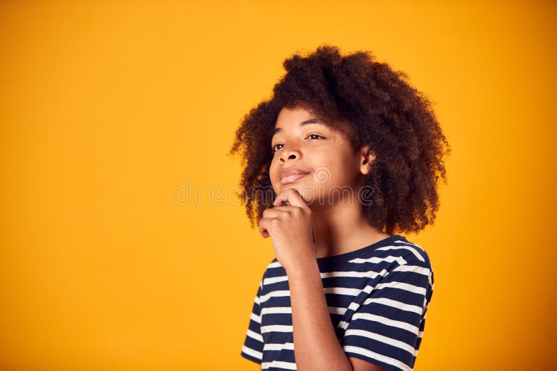 Studio Shot of Boy with Puzzled Expression Thinking Against Yellow ...