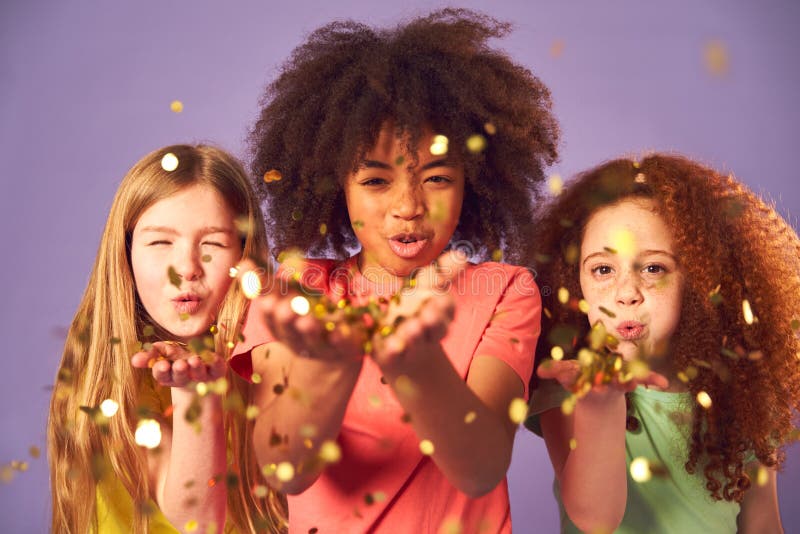 Studio Shot of Children Blowing Glitter from Hands on Purple Background ...