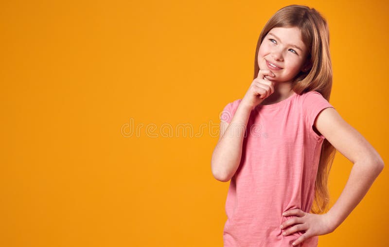 Studio Shot of Girl with Puzzled Expression Thinking Against Yellow ...