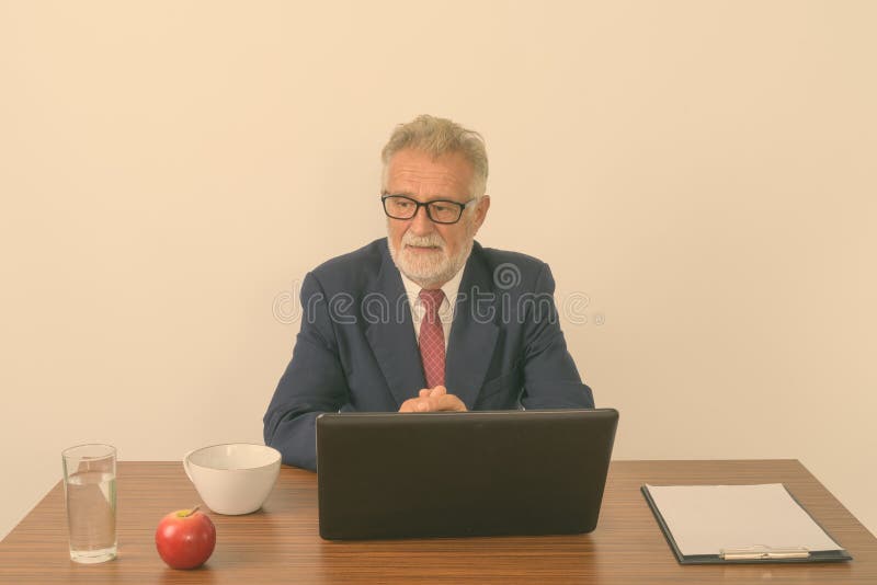 Studio Shot of Handsome Senior Bearded Businessman Thinking while ...