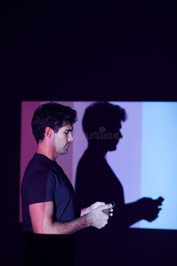 Studio Shot of Man Using Mobile Phone with Light Casting Shadow in ...