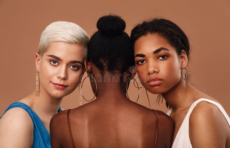 Three Diverse Women Standing Against Brown Background Stock Image ...