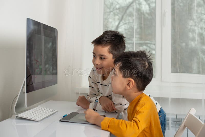 Boys Enthusiastically Draw on a Computer Using a Tablet Stock Photo ...