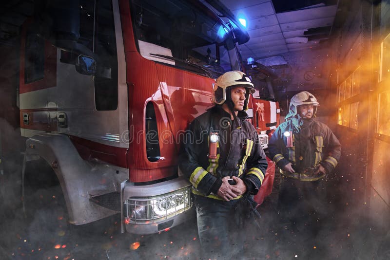 Two Firefighters Dressed in Workwear with Helmets in Fire Station Stock ...