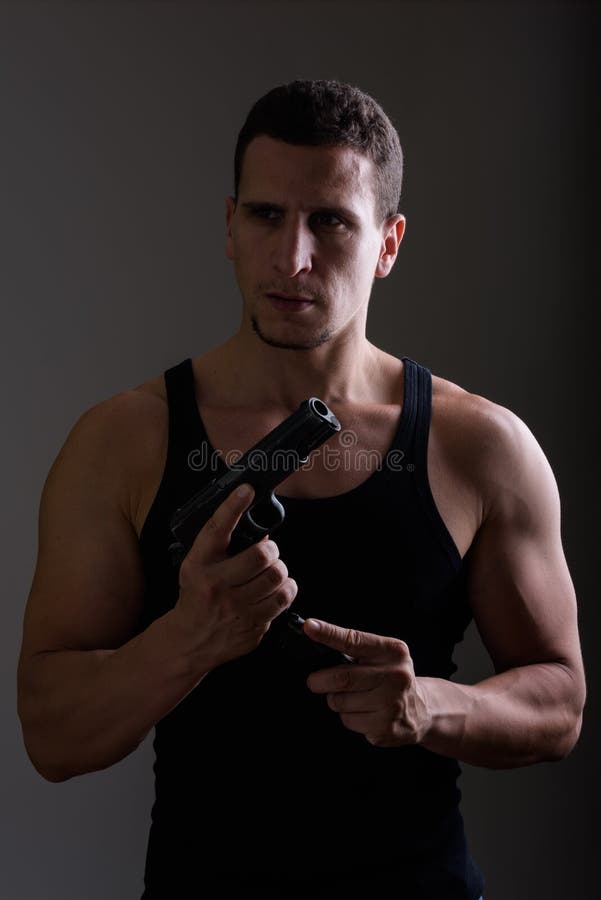Studio Shot of Young Muscular Persian Man Reloading Gun while Th Stock ...