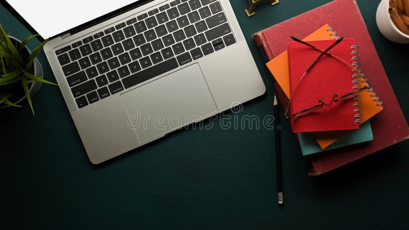 Study Table with Laptop, Stack of Books, Eyeglasses, Stationery and ...