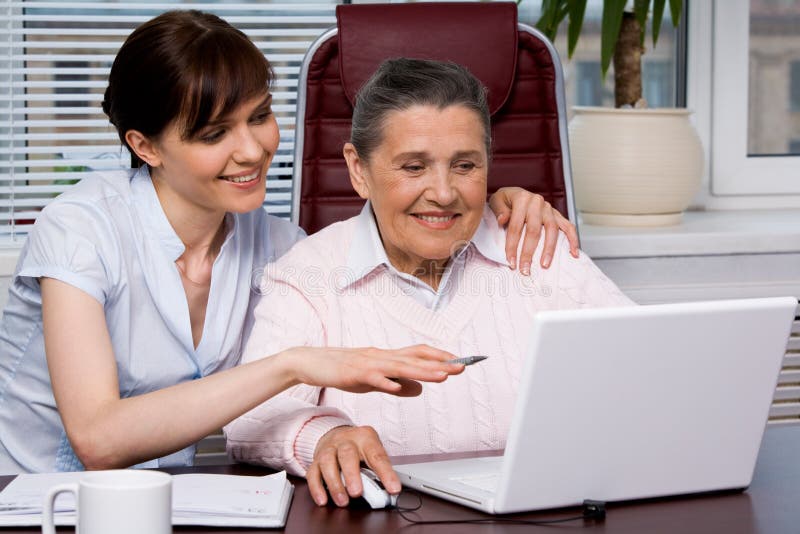 Younger Woman Helping an Elderly Person Using Laptop Computer for ...