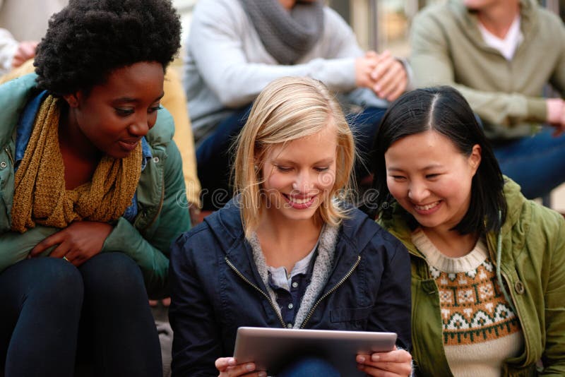 Studying on the Go. a Group Students Looking at a Tablet on Campus ...