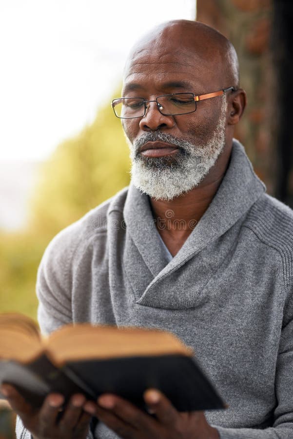 Studying the Scriptures. a Handsome Senior Man Reading His Bible while ...