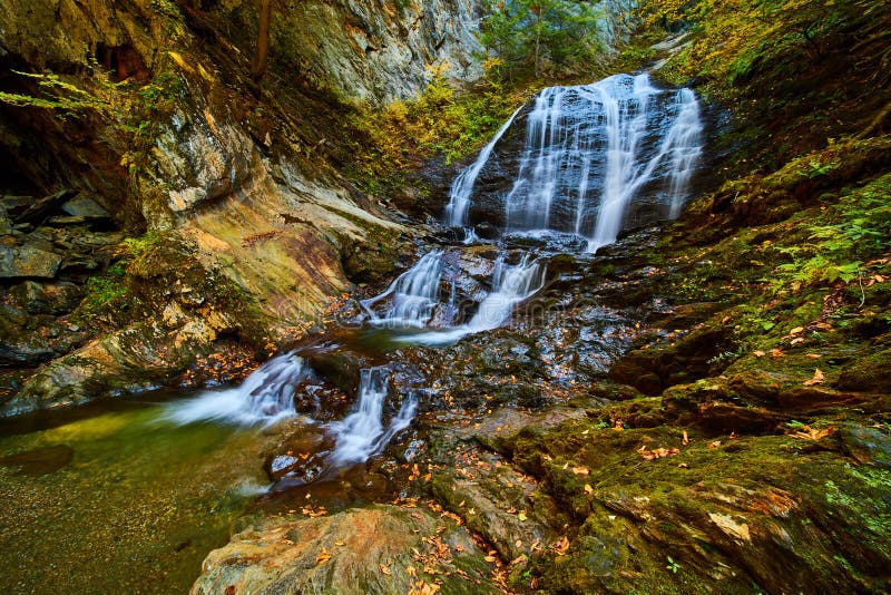 Stunning Cliffs with Fall Leaves Surround Large Waterfall Raging Over ...