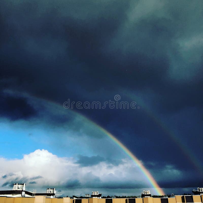 Double Rainbow Over Dark Storm Clouds and Rooftop after Heavy Rain ...
