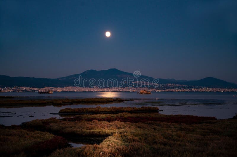 The Full Moon with the Lights of Mountains in the Distance Stock Image ...