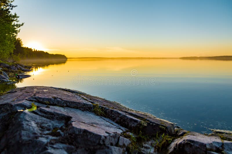 Stunning Sunset on the Rocky Shore of the Lake, Smooth Surface of the ...