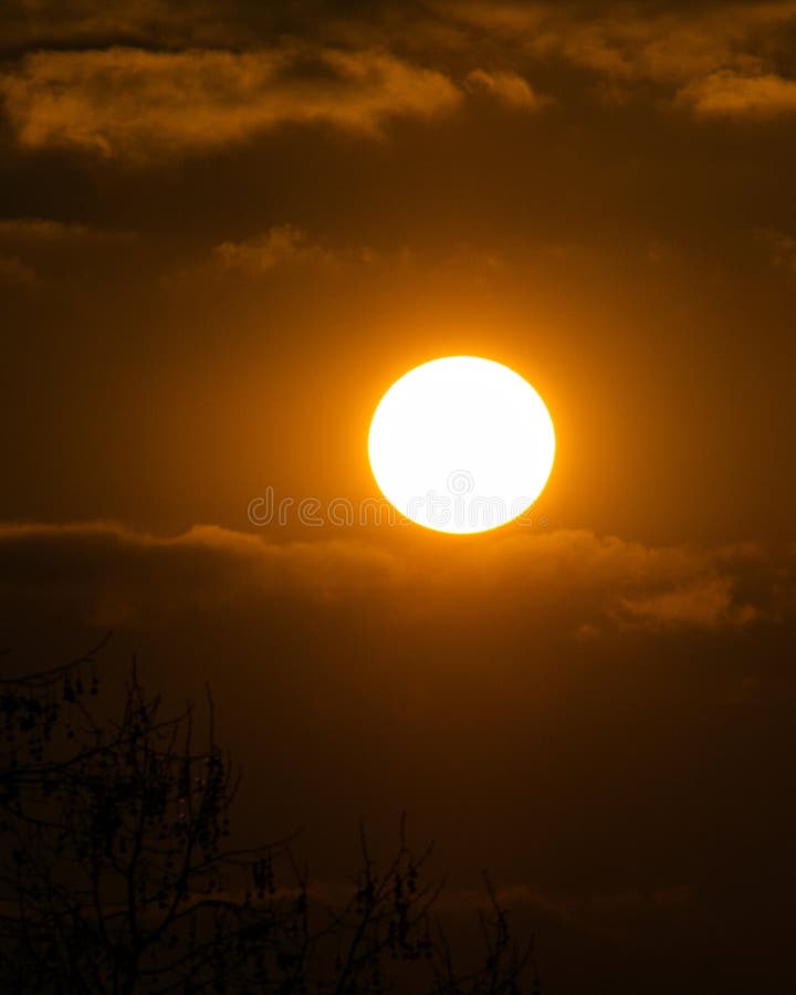 Stunning Vertical Shot of the Bright Sun at Sunset Above the Beautiful ...
