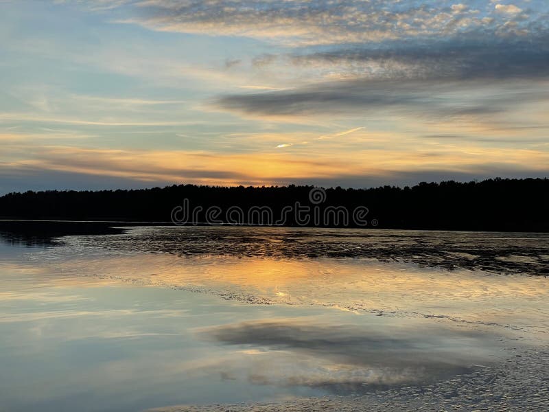Stunning View of an Orange Cloudy Sunset Sky Reflected on a Mirror-like ...