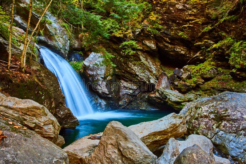 Stunning Waterfall into Boulders Surrounded by Forest and Cliffs Stock ...