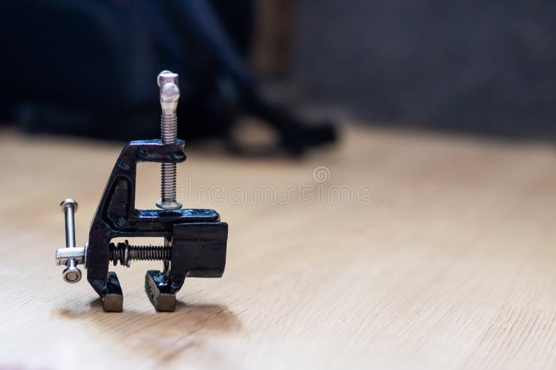 A Clamp with an Adjustable Rests on a Wooden Table Stock Photo - Image ...