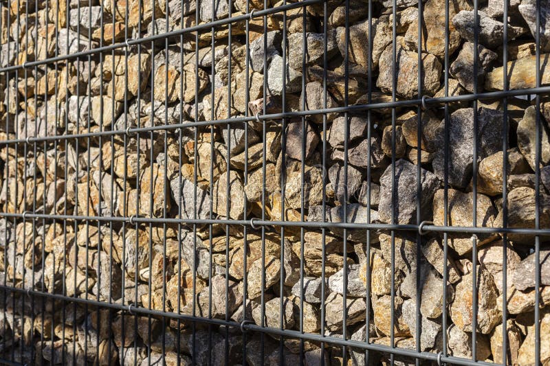 A Sturdy Wall Made of Various-sized Stones Secured by a Metal Grid. the ...