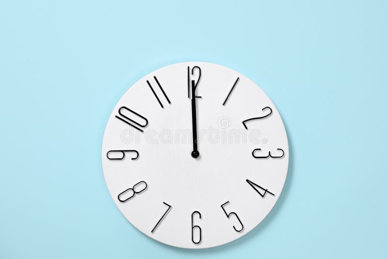 Stylish Analog Clock Hanging on Light Blue Wall Stock Photo - Image of ...