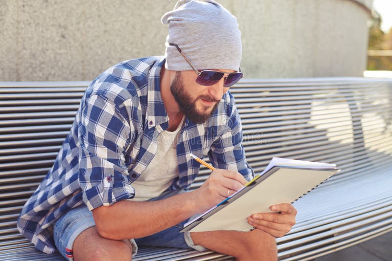Stylish Bearded Man Sitting on Bench and Writing Stock Photo - Image of ...