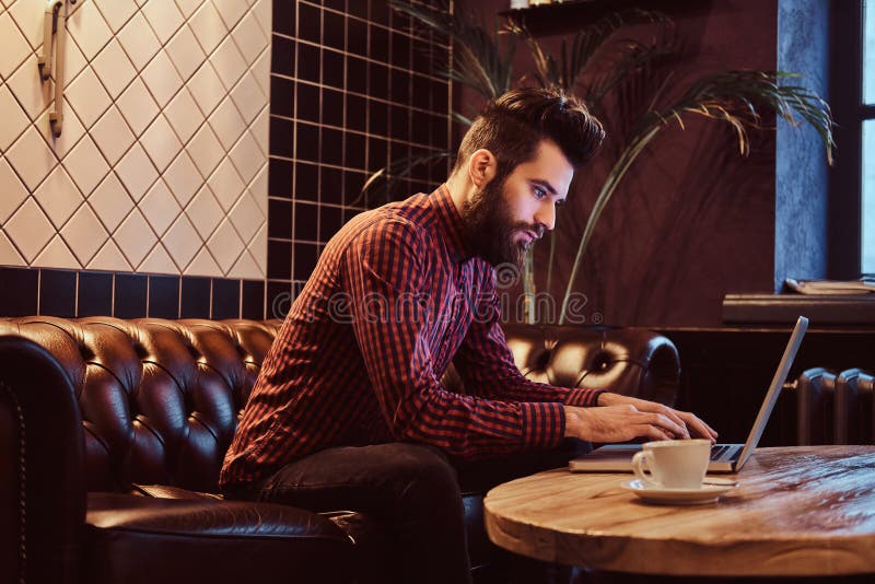 Stylish Bearded Student during Break Sitting on Sofa at the Cafe and ...