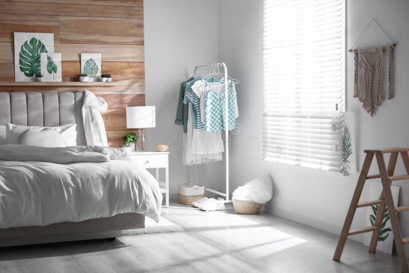 Stylish Bedroom Interior with Clothing Rack and Large Window Stock ...