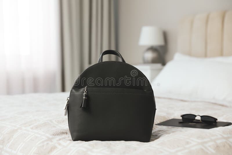 Stylish Black Backpack, Tablet and Sunglasses on Bed in Room Stock ...