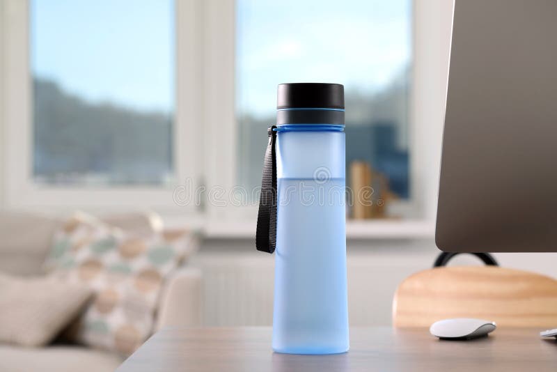 Stylish Bottle of Water and Computer on Table at Workplace in Office ...