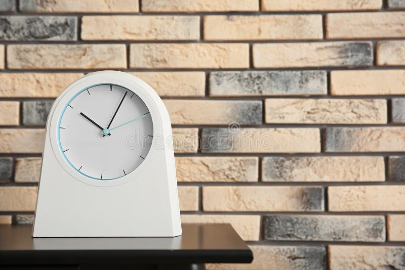 Stylish Clock on Table Near Brick Wall Stock Image - Image of deadline ...
