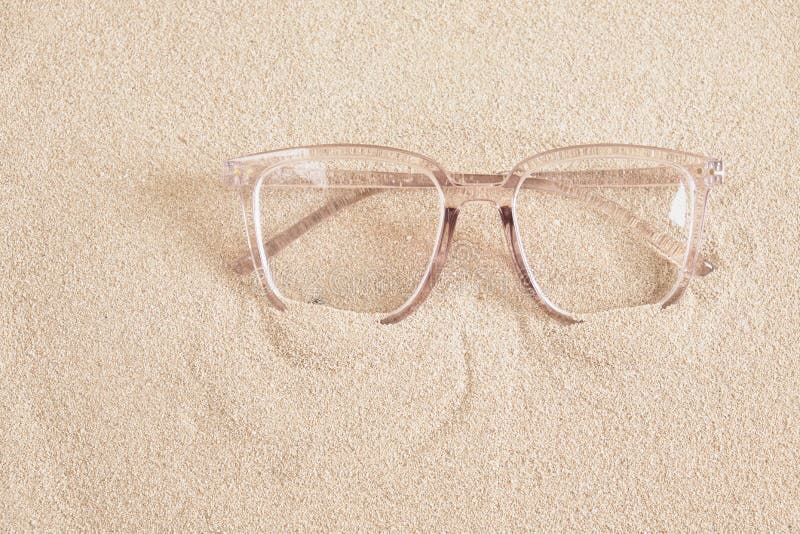 Stylish Eye Glasses in a Transparent Plastic Frame on the Sand Stock ...