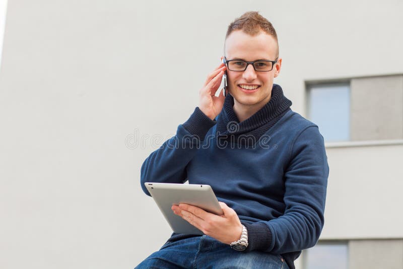 Stylish Guy Connected on Internet with Tablet and Mobile Phone in Town ...
