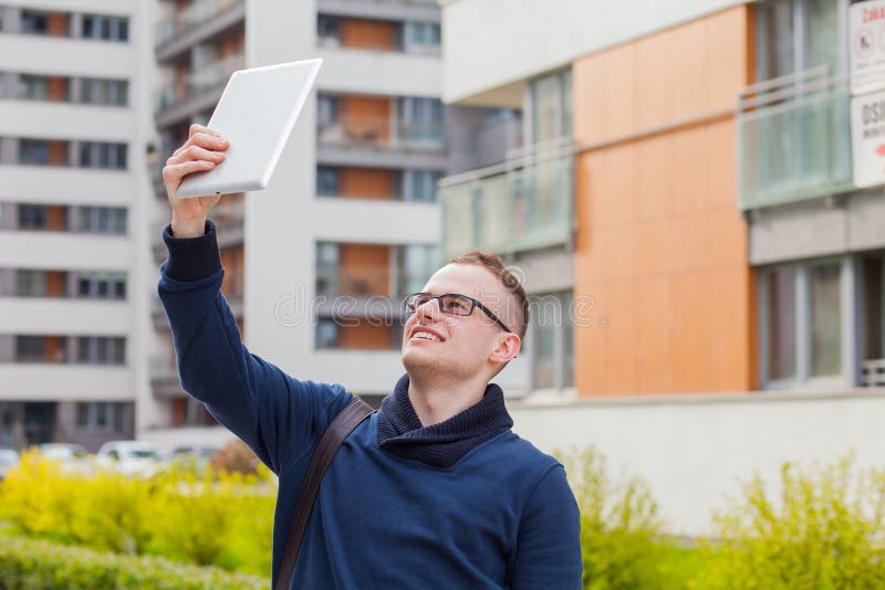Stylish Guy Connected on Internet with Tablet in Town. he is Hap Stock ...