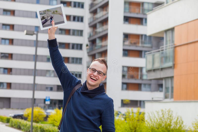 Stylish Guy Connected on Internet with Tablet in Town. he is Hap Stock ...