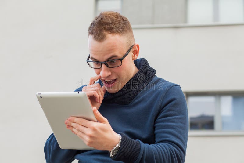 Stylish Guy Connected on Internet with Tablet in Town. he is Surprised ...