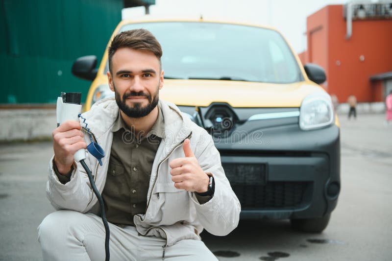 Stylish Man Inserts the Charging Cable into the Socket of Electric Car ...