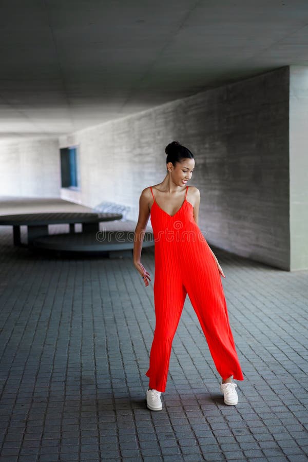 A Stylish Model Dressed in a Bright Red Jumpsuit Posing Gracefully in a ...