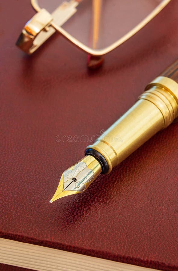 Stylish Pen with a Gold Plated Pen and Glasses on Brown Notepad for ...