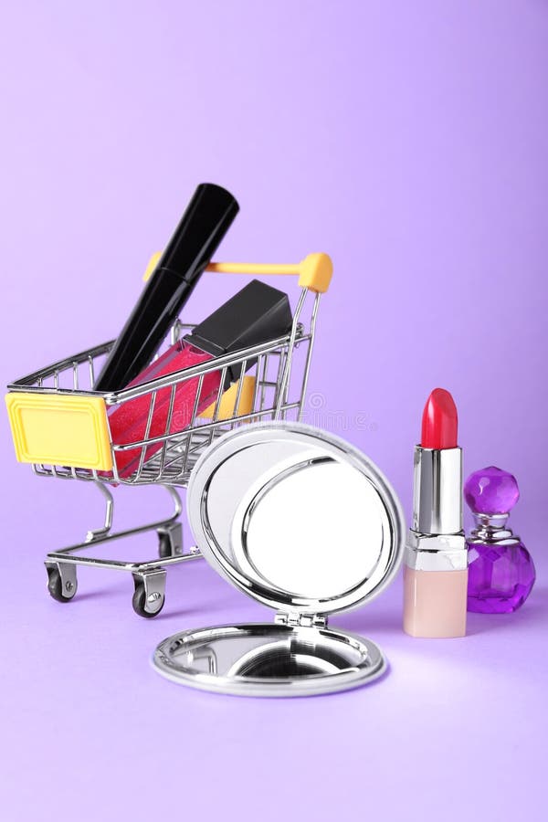 Stylish Pocket Mirror and Makeup Products on Lilac Background Stock ...