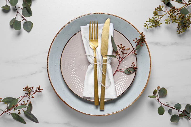Stylish Setting with Cutlery and Eucalyptus Leaves on White Marble ...