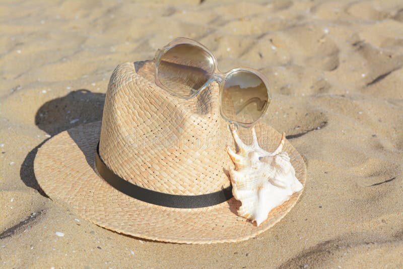 Stylish Straw Hat, Sunglasses and Sea Shell on Sandy Beach Stock Image ...