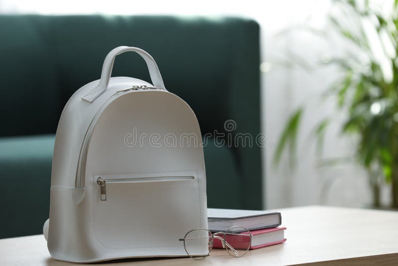 Stylish White Backpack, Notebooks and Glasses on Wooden Table Indoors ...