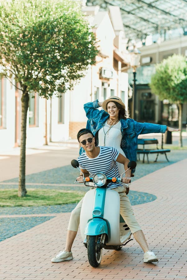 Stylish Young Couple Riding Scooter and Smiling at Camera Stock Photo ...