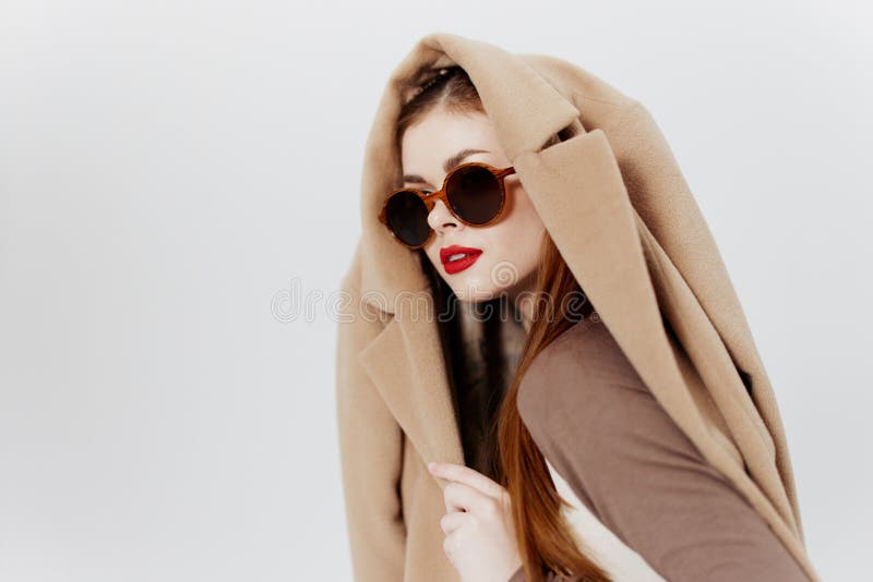 Stylish Young Model with a Coat on Her Head Poses with Glasses in the ...